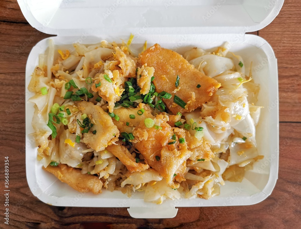 Stir fried rice noodles with chicken on a foam box container. Thai ...