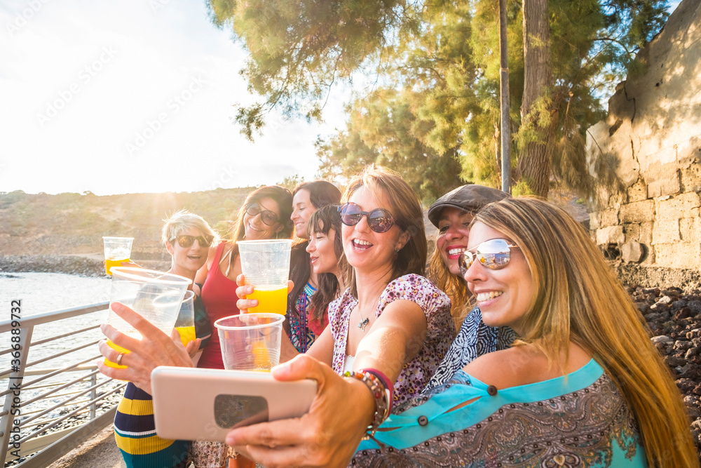 Fun at the beach with cheerful female people with fresh healthy drinks ...