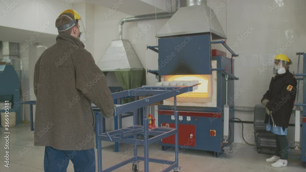 A factory workers with protective mask from coronavirus infection puts ...