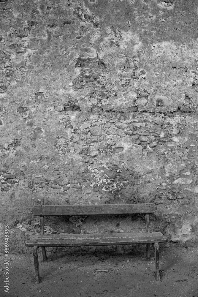 Foto de Old abandoned bench in front of a house. Ancient brick wall ...