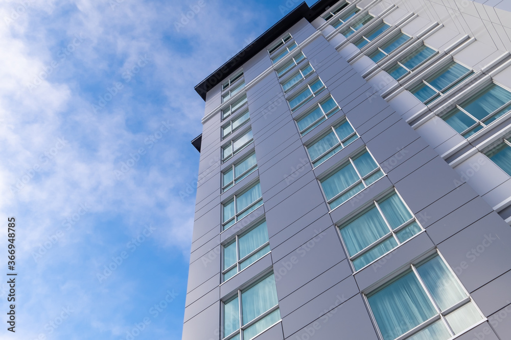 The exterior corner of a tall grey building. The wall is made from ...