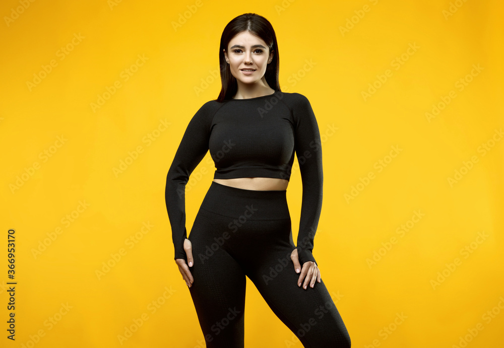 Gorgeous body positive Latin woman in a black suit on a yellow ...