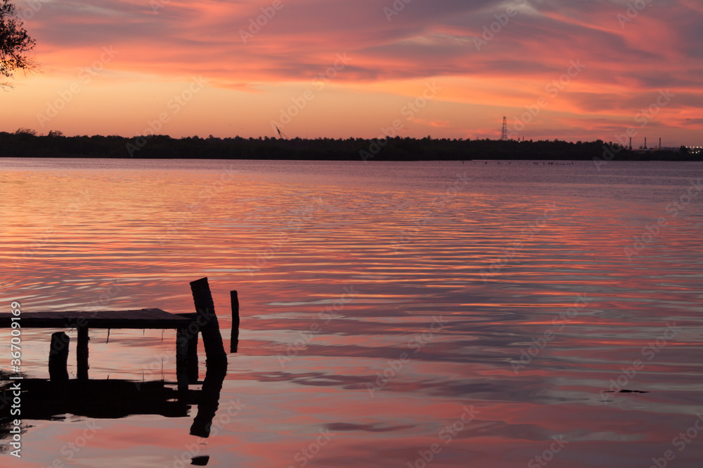 Beautiful view of the sunset and reflections of wooden port on the ...