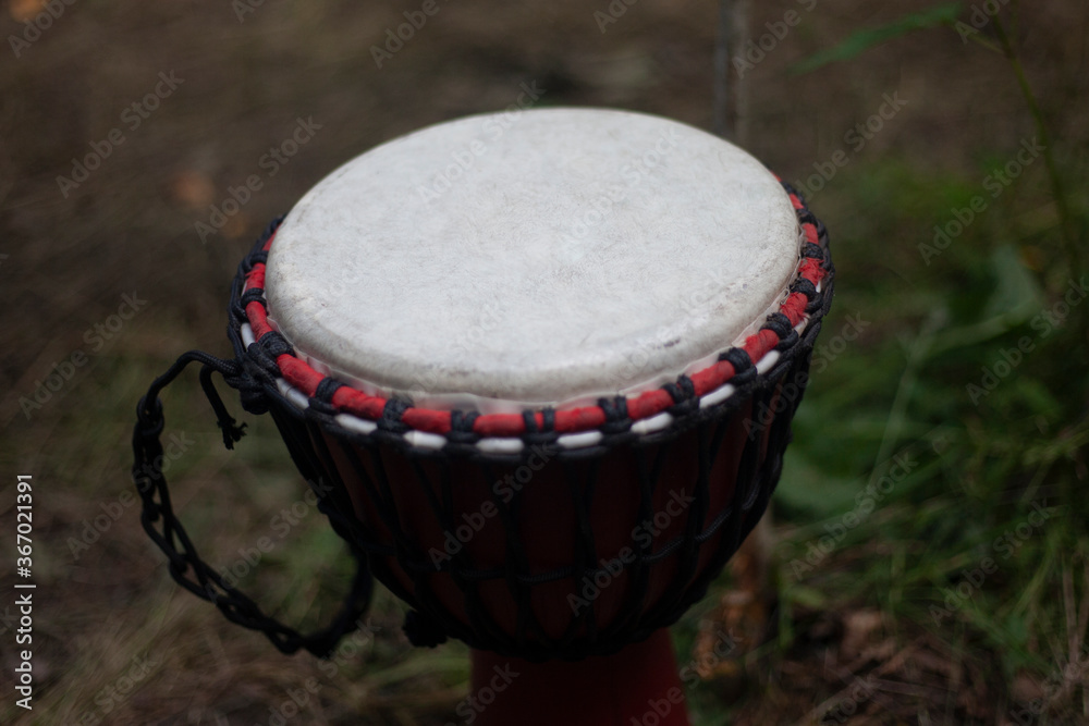 African drum. Dark frame with a drum standing outside in the forest ...