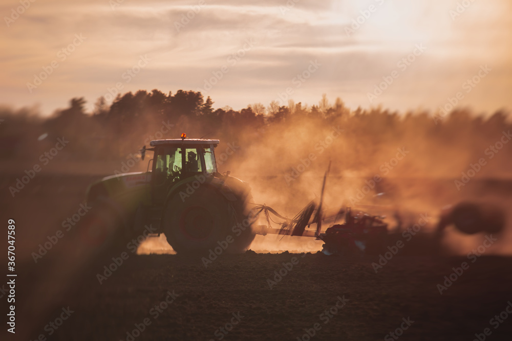 Foto de Tractor with a disc harrow system harrows the cultivated farm ...
