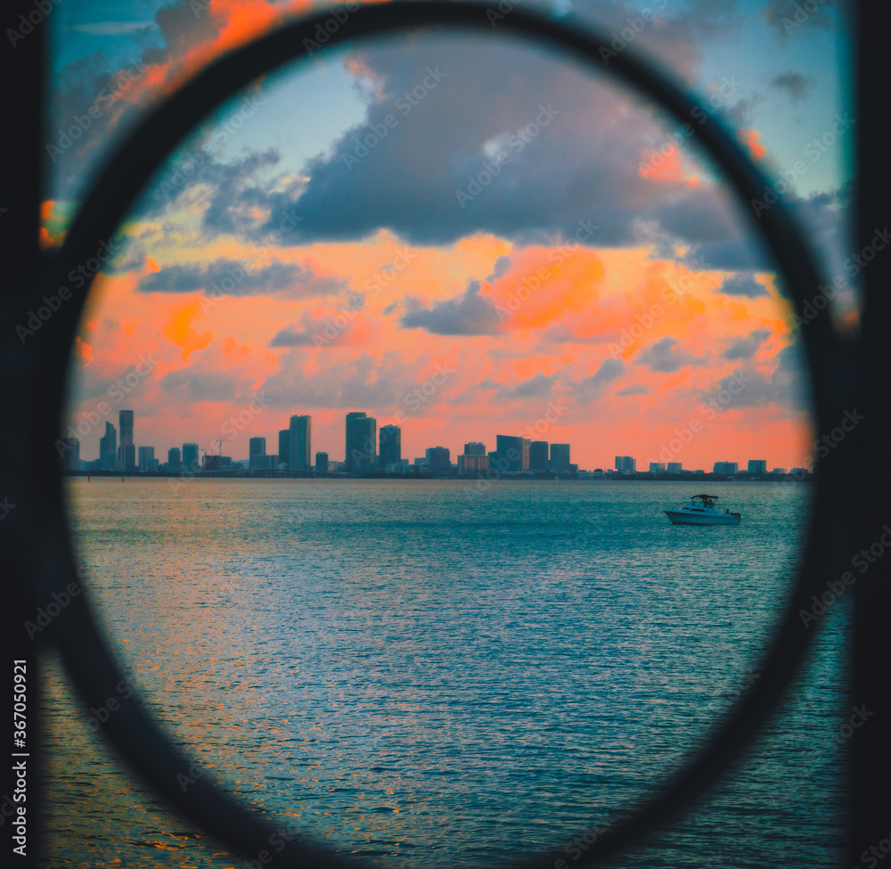 magnifying glass over city skyline sunset miami florida buildings boat ...