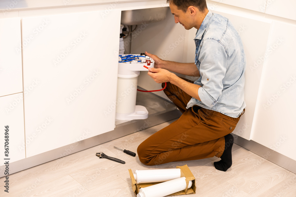 Plumber installs a water filter. water filter. Stock Photo | Adobe Stock
