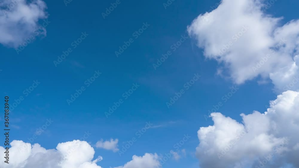 blue clear sky and fluffy clouds, blue space at the centre of footage ...
