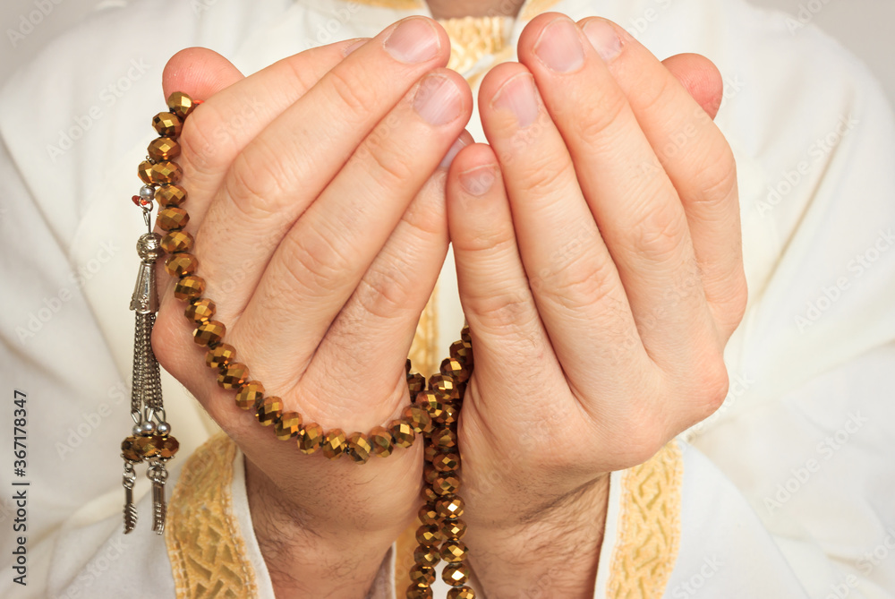 Religious caucasian muslim man with imam robe praying with prayer beads ...