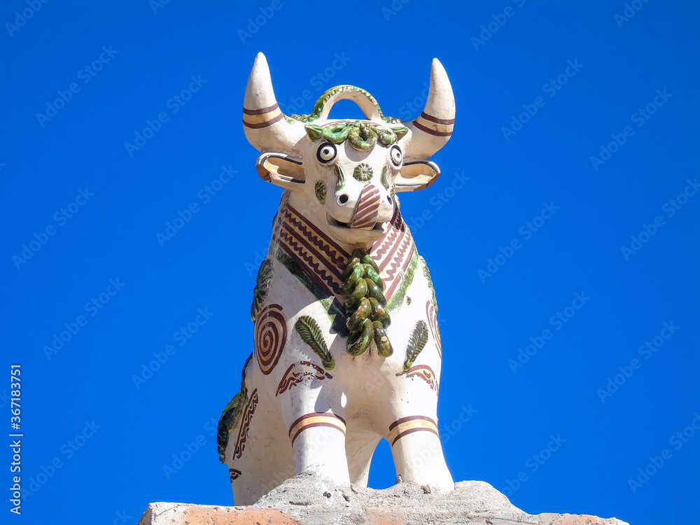 Typical Peruvian bull figurine on top of a roof. These figurines are ...