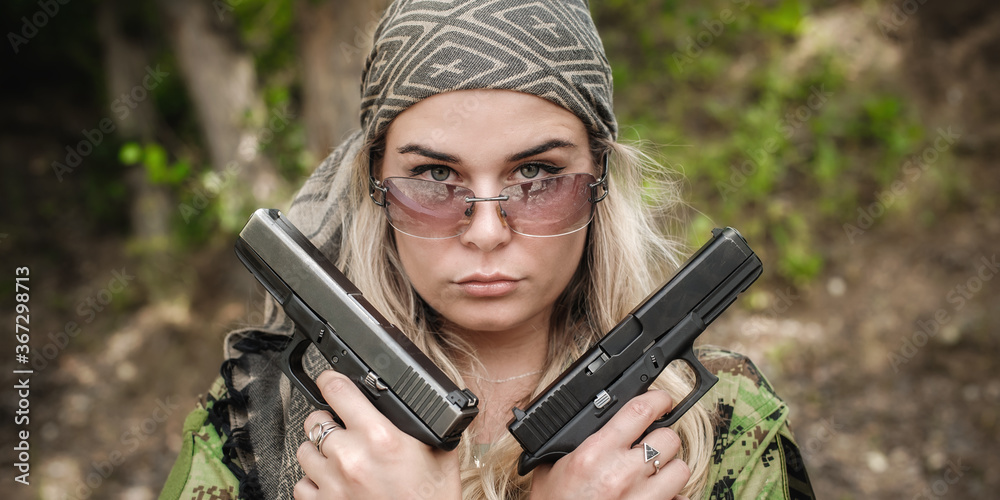 Beautiful and attractive female army soldier posing with two guns ...