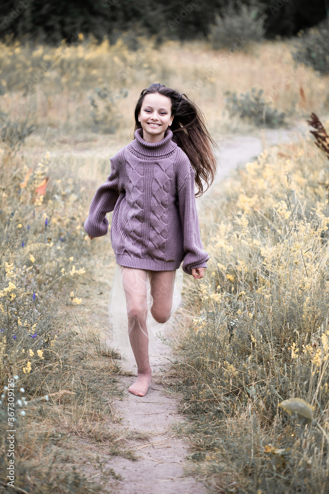 Smiling happy girl running barefoot in the meadow. Freedom concept ...