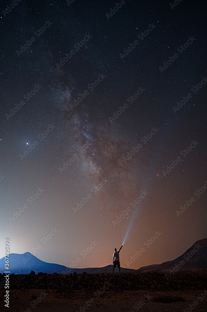 Silueta de persona con linterna con la vía láctea Stock Photo | Adobe Stock