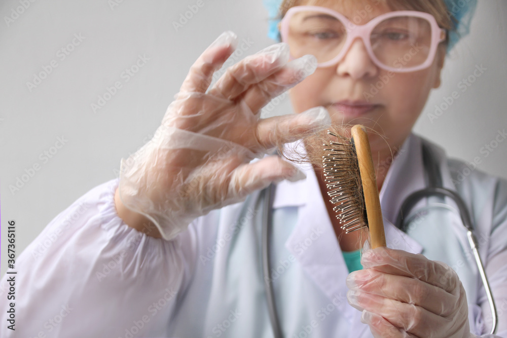 pharmacist, scientist, doctor holds a comb and removes hair for a test ...