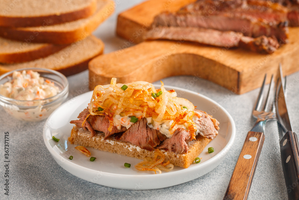 Rye bread sandwich with roast beef, fried onions, mayonnaise and ...
