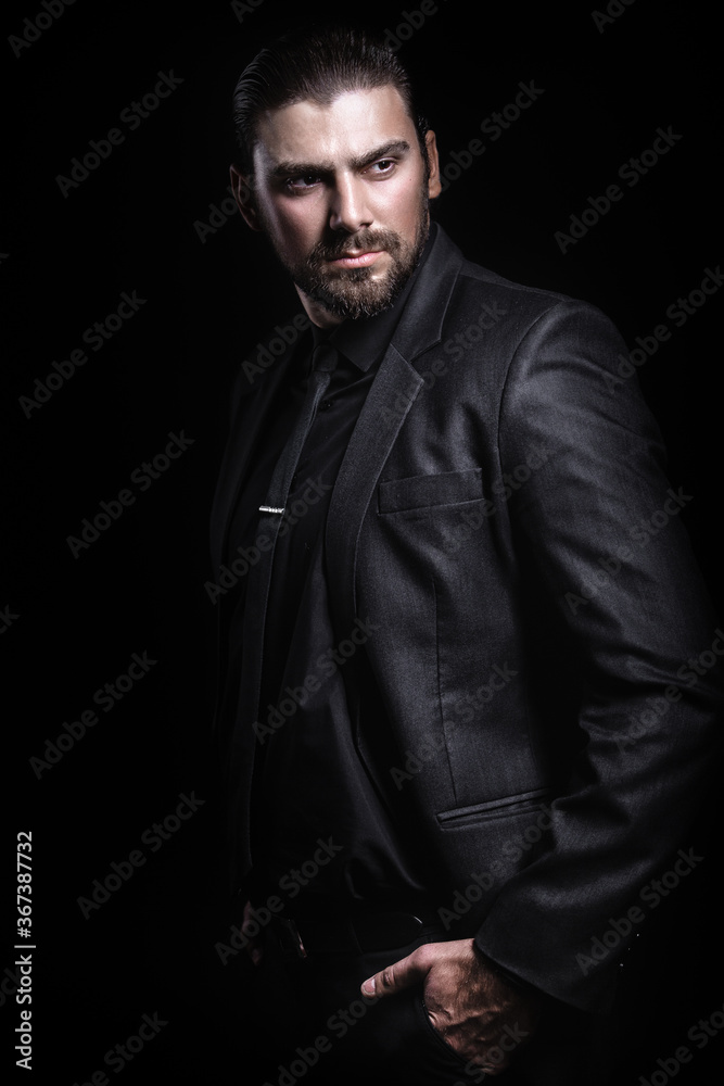 Young white Caucasian man on a black background in a black jacket ...
