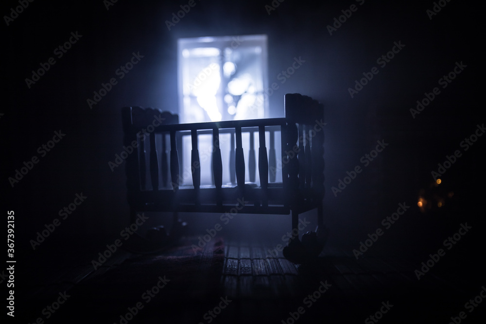 Old creepy eerie baby crib near window in dark room. Scary baby ...