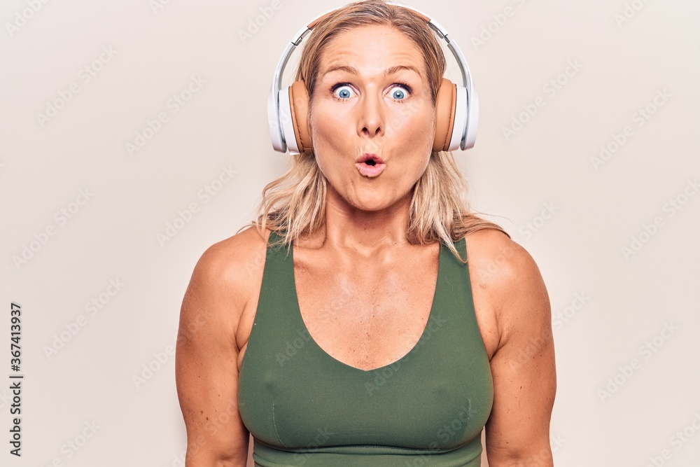 Middle Age Caucasian Blonde Woman Listening To Music Using Headphones