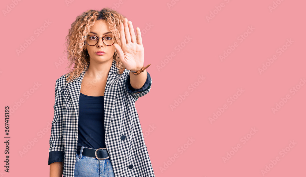 Young blonde woman with curly hair wearing business jacket and glasses ...