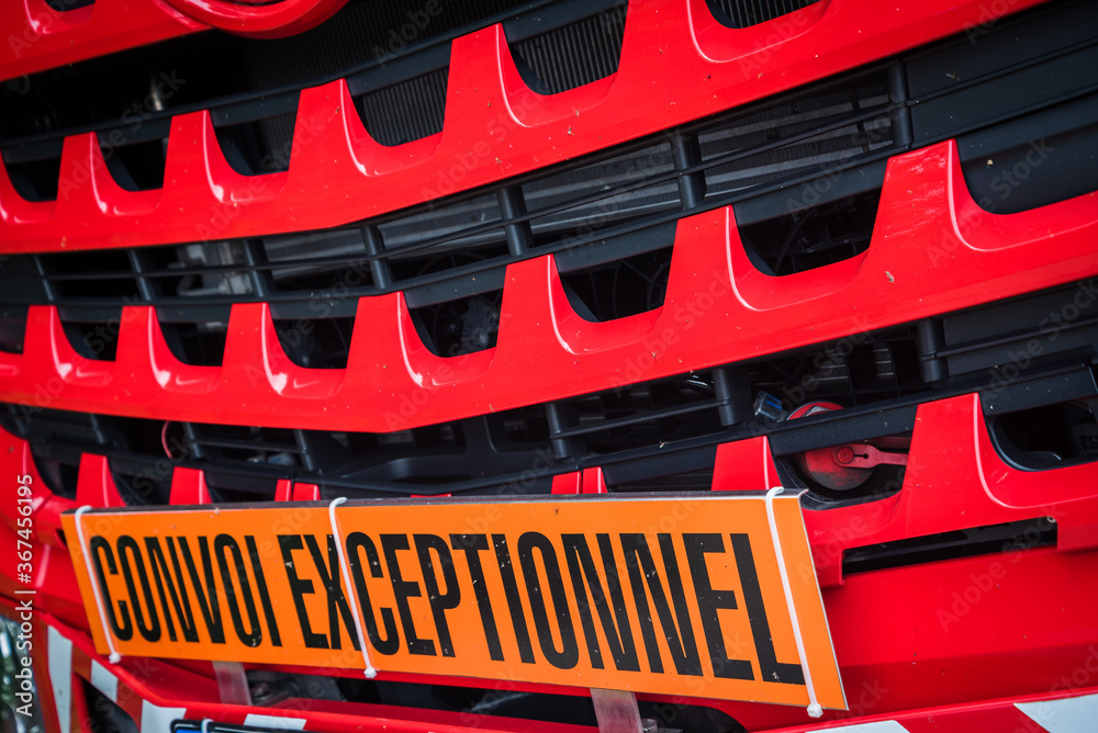 Orange banner in the front of the truck with french text Convoi ...