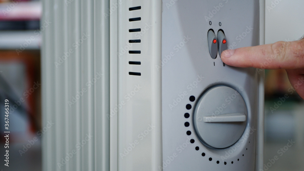 Man Sets the Heating Temperature of an Electric Radiator at Home in a ...