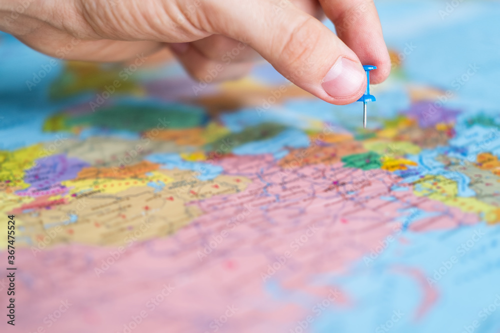 Man pins a new destination on a world map, for his next trip. Travel ...