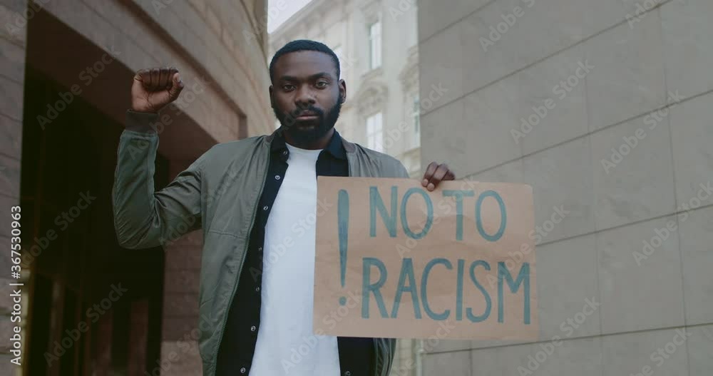 African american man raising up clintched fist and holding carton ...