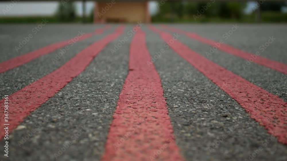 Close-up of asphalt with volumetric red road markings. Cars moving on a ...