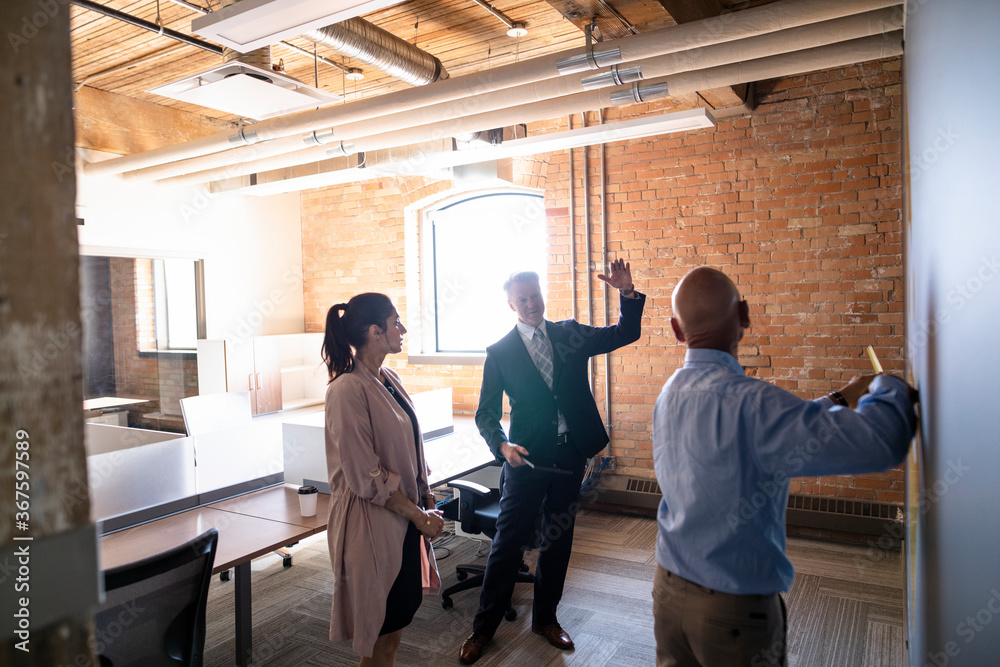 Business people measuring wall in new office Stock Photo | Adobe Stock