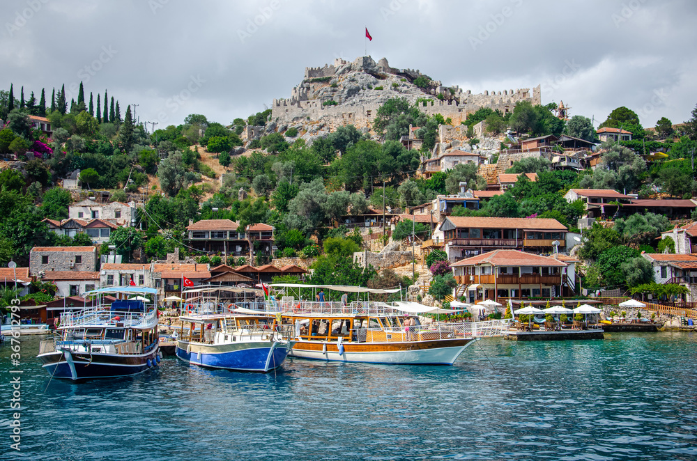 Ancient village of Simena with castle on mountain. Boat dock, beautiful ...