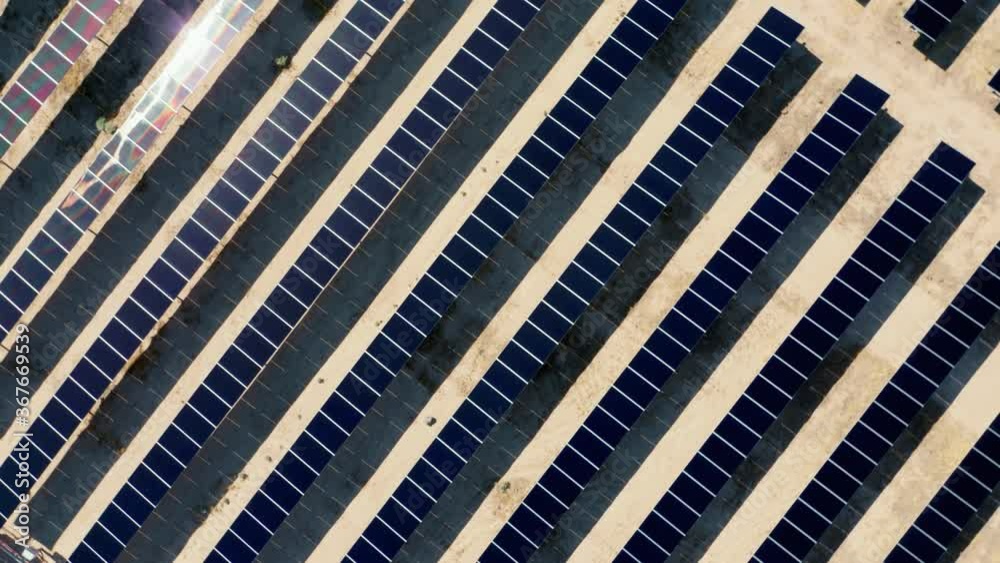 Cinematic circular overhead drone shot of the straight rows of solar ...