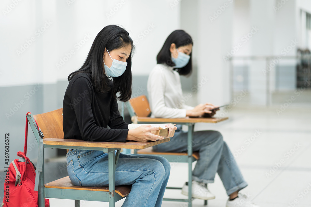 Female teenager college students wears face mask and keep distance ...
