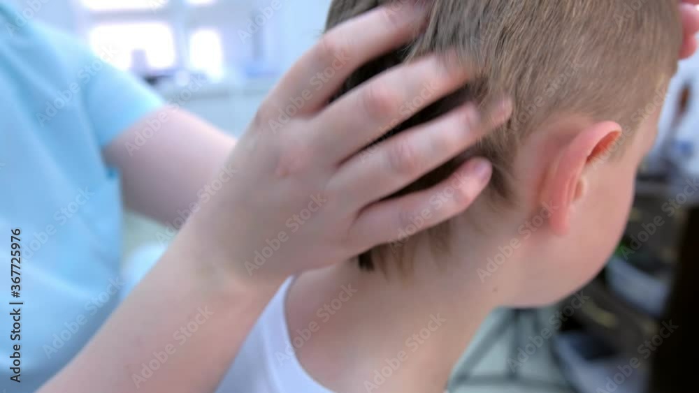 Doctor professional masseur making therapy head massage to teen boy in ...