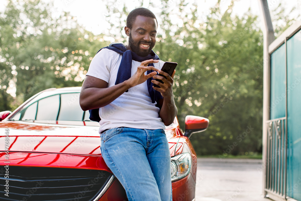 Happy smiling African guy is ready for a journey by car. Handsome young ...