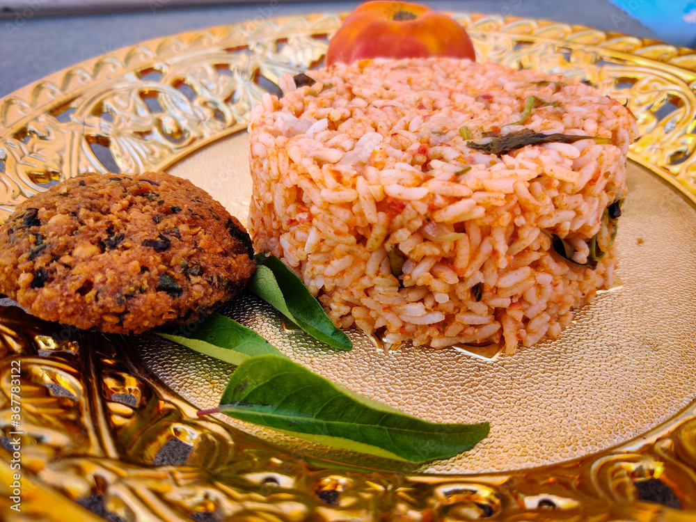 Tasty Tomato rice with vada kept in gold plate. A south Indian recipe ...