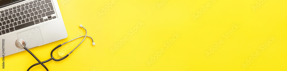 Stethoscope keyboard laptop computer isolated on yellow background ...