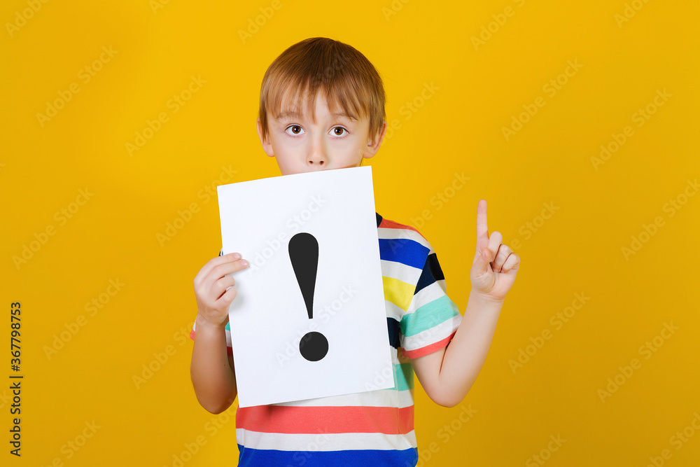 Cute boy holding paper sheet with exclamation mark. Thoughtful child ...