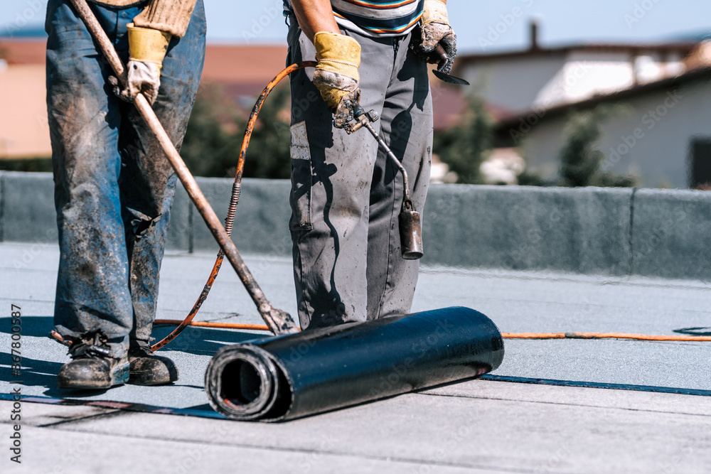 Rooftop waterproofing details. Workers installing bituminous membrane ...