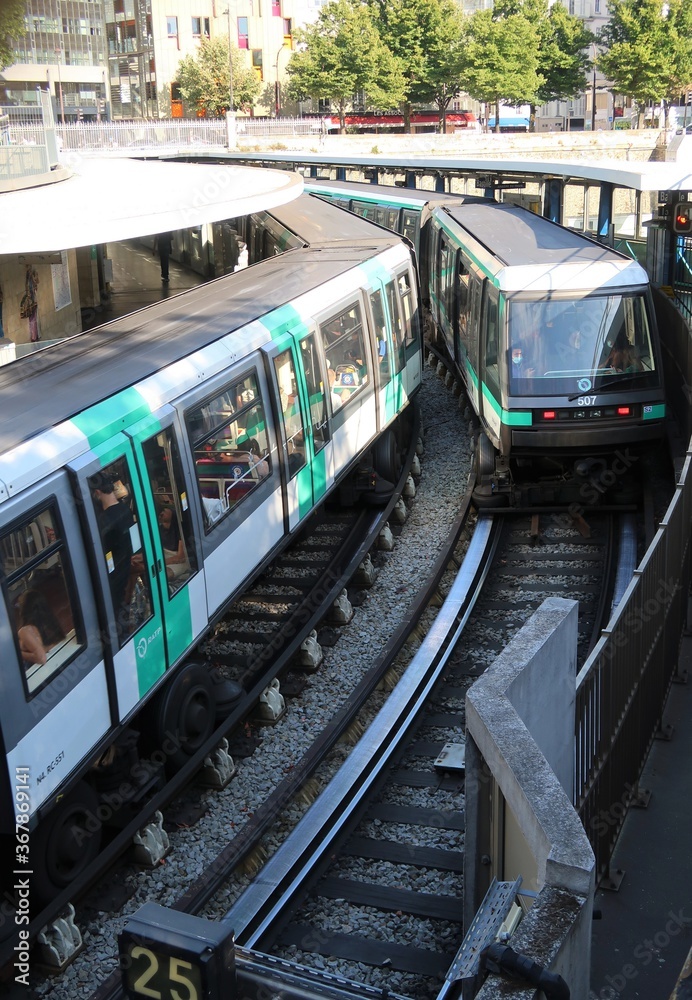 Vue sur des rails et deux métros se croisant dans une station de métro ...