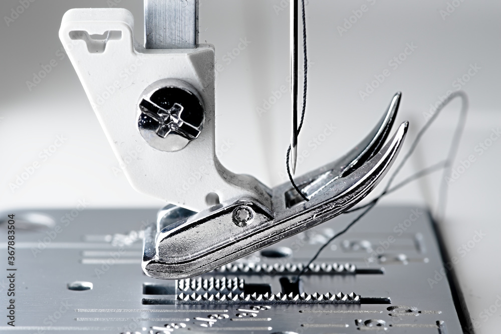 4 - Super macro side view of the needle and thread of a sewing machine ...