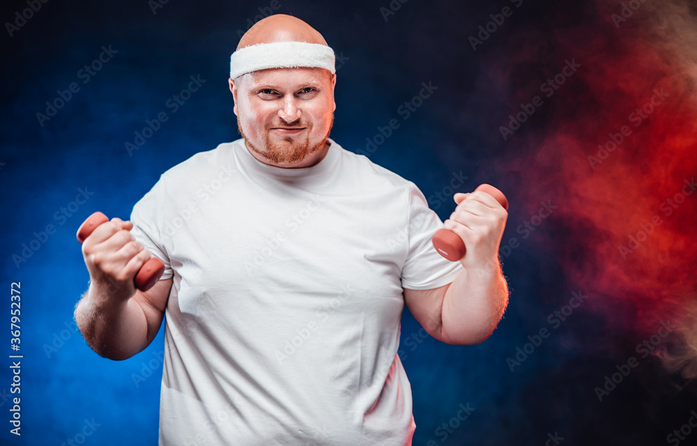 Burly man in a white tracksuit holds dumbbells in his hands and very ...