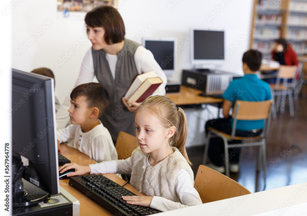 Portrait of serious tween girl during lesson in computer room of school ...