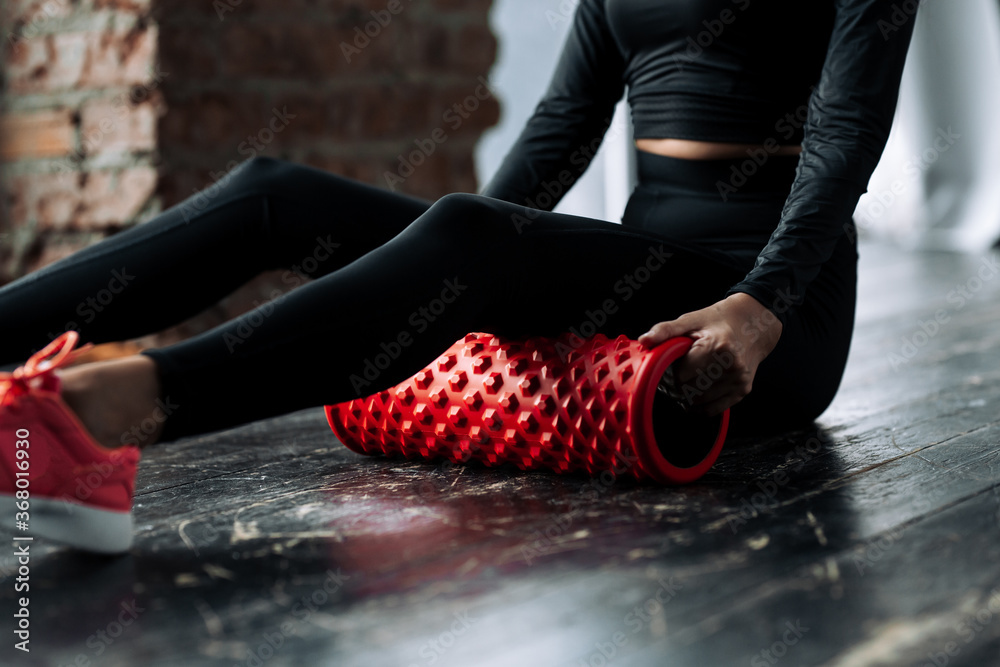 Close-up of a young woman in a black tracksuit performs a warm-up ...