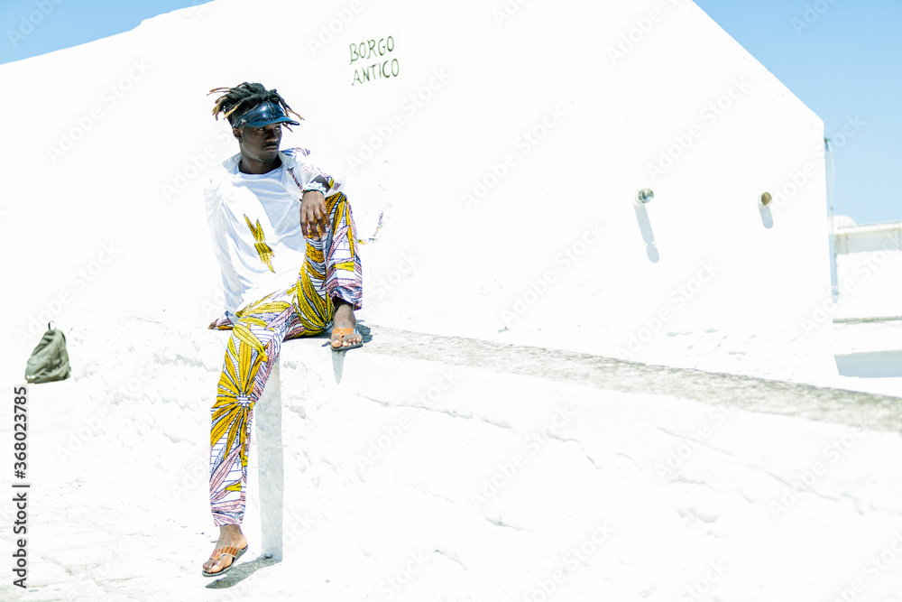 Italian immigrant man of sub-Saharan origin with sun hat and black and ...