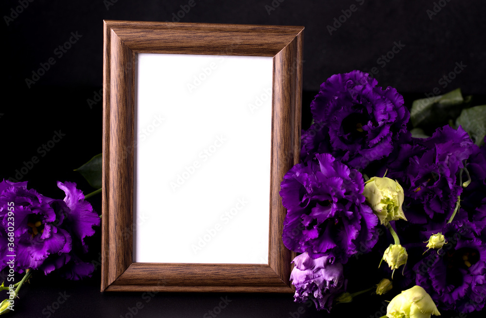 Empty mourning photo frame next to purple flowers. Sorrow concept Stock ...