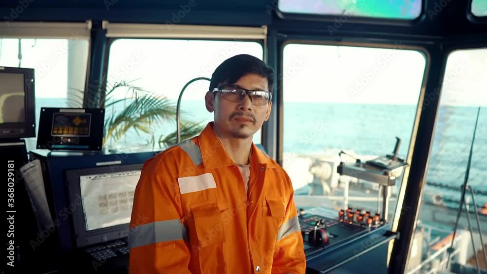 Filipino deck Officer on bridge of vessel or ship wearing coverall ...