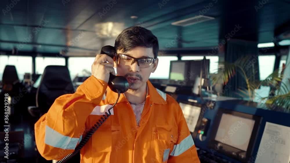 Filipino deck Officer on bridge of vessel or ship wearing coverall ...