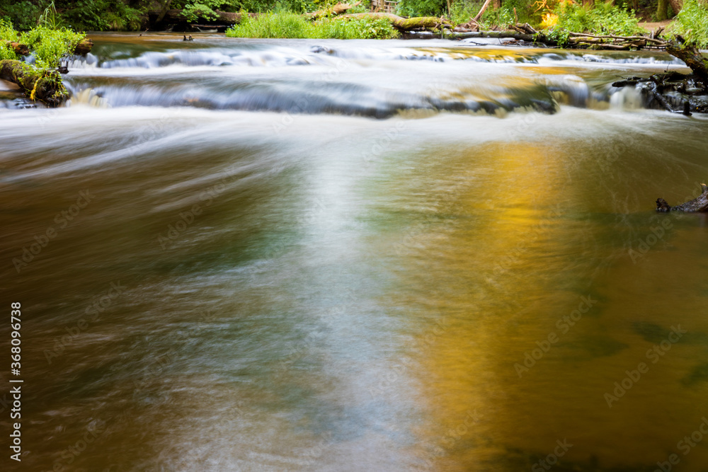 Smooth blurred water surface abstract background. Small cascades on ...