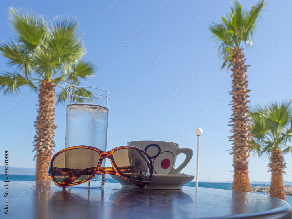 Café con leche y vaso de agua contemplando el paisaje de la costa en ...