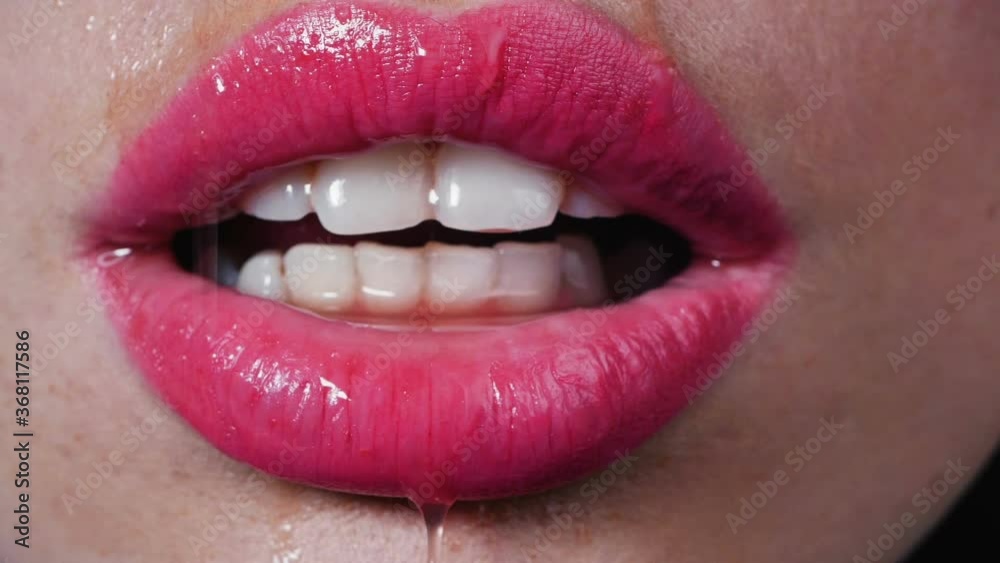Water drops drip on beautiful female lips, сlose-up. Woman seductively ...